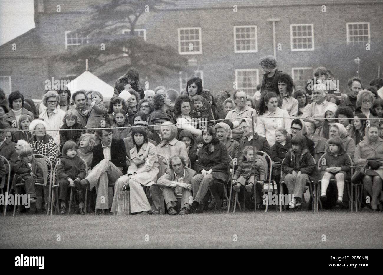 1970s, historical, spectators standing and sitting behind a rope at an ...