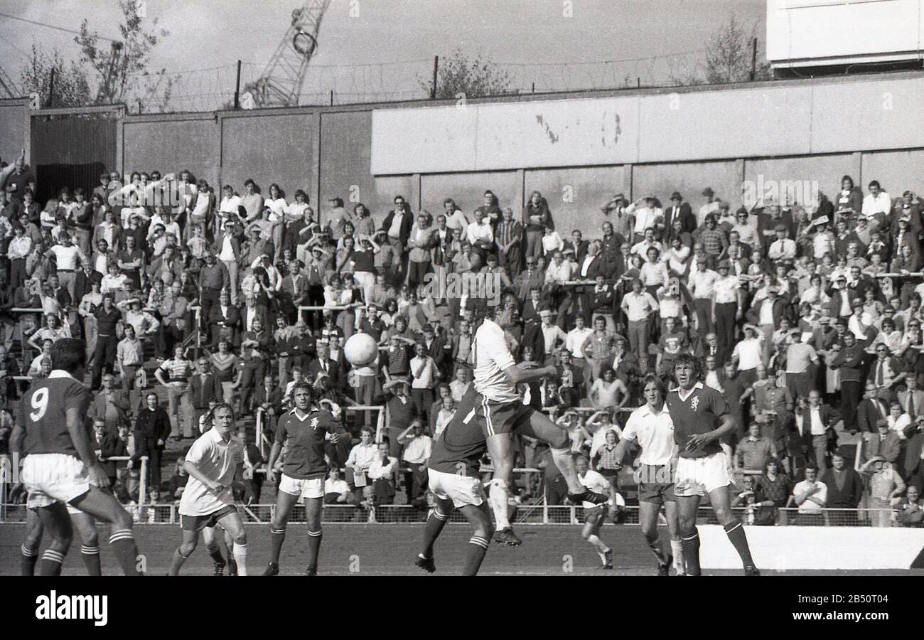 1970s, historical, fans watching a football match standing on the ...