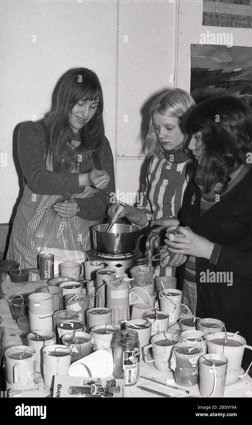 1970s, historical, young women making candles, using a DIY candle ...
