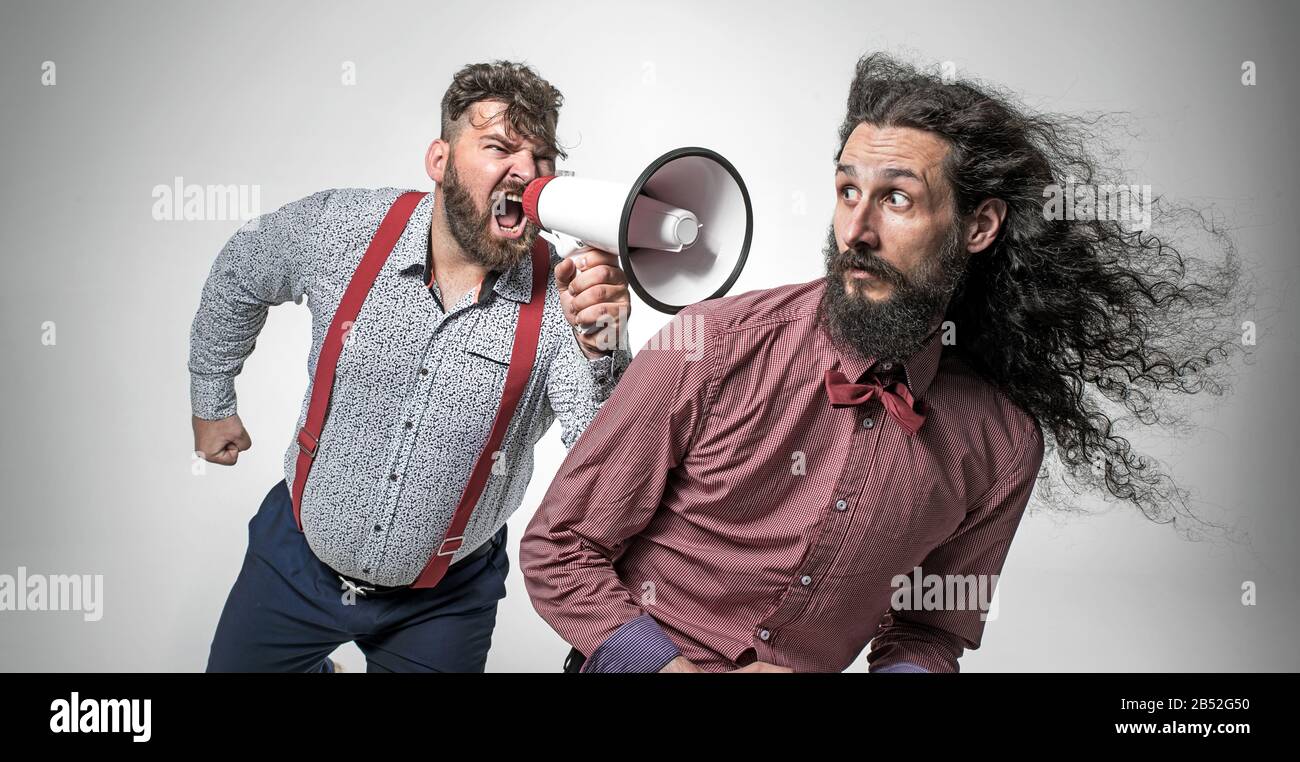Angry boss yelling on the skinny, scared employee Stock Photo - Alamy