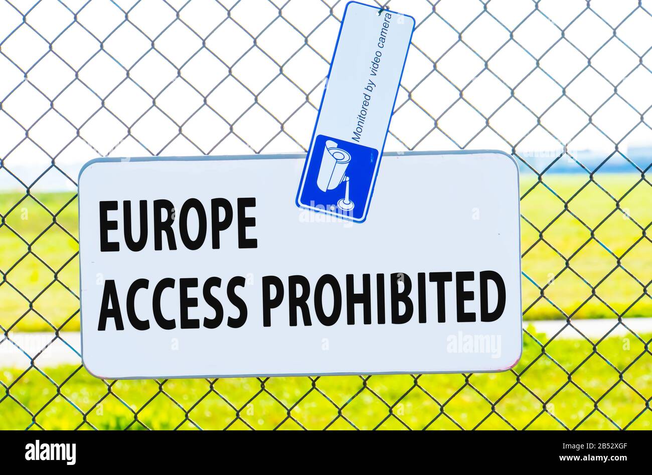 Rectangulardanger sign at a metal border chain-link fence in front of a ...