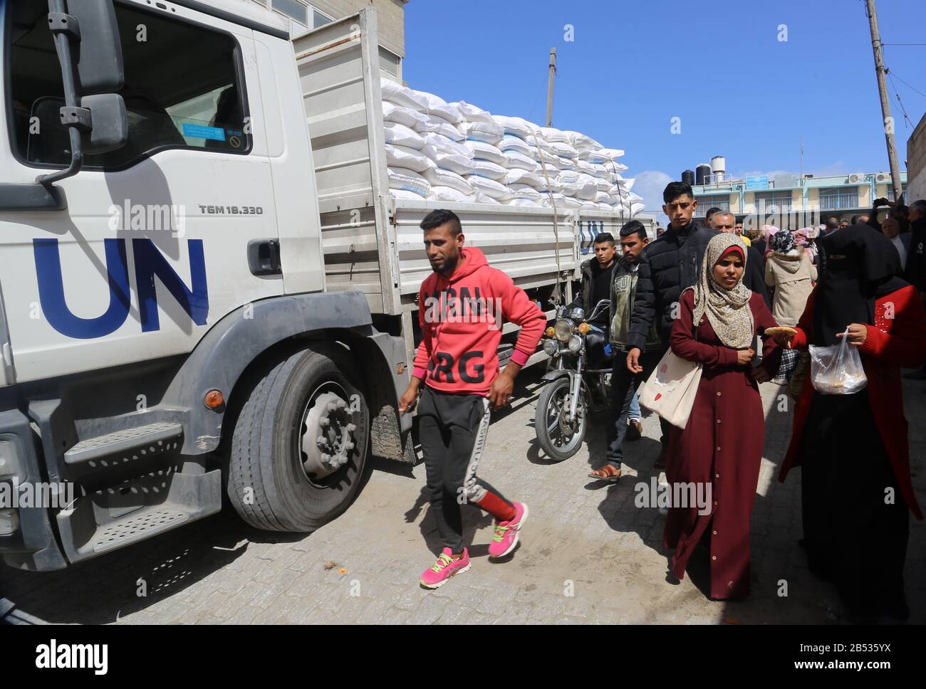 Palestinians receive their monthly food aid at a United Nations ...
