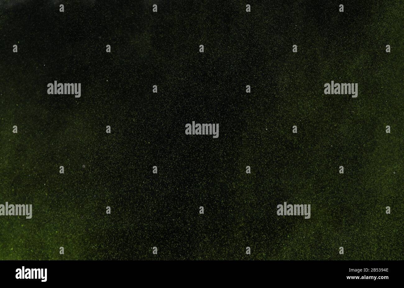 abstract powder splatted background. Green color powder explosion on ...