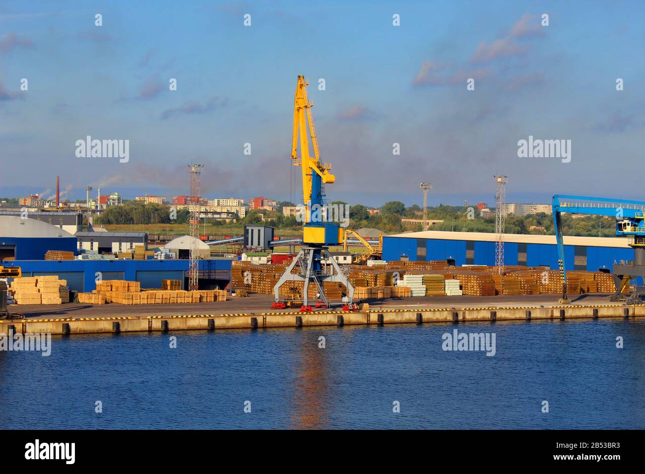 Industrial port with cranes and sawn timber Stock Photo - Alamy