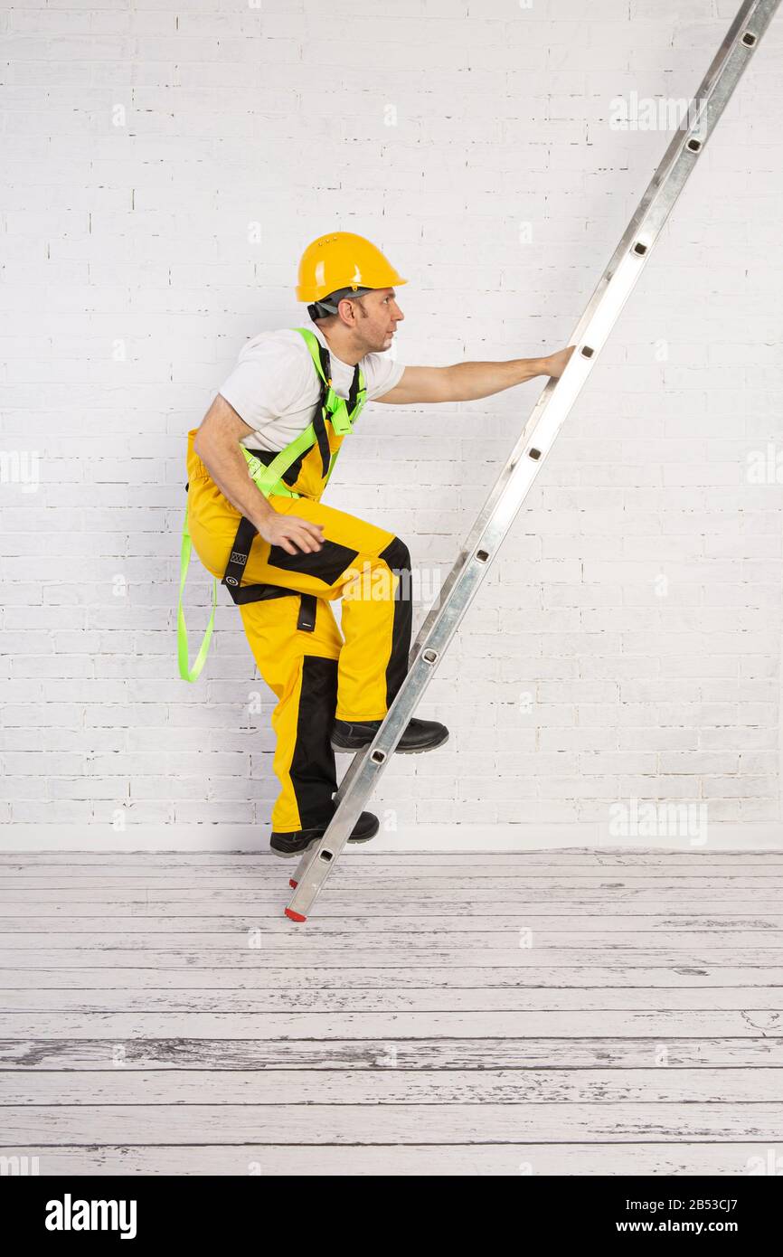 Irresponsible use of a ladder during construction work Stock Photo - Alamy