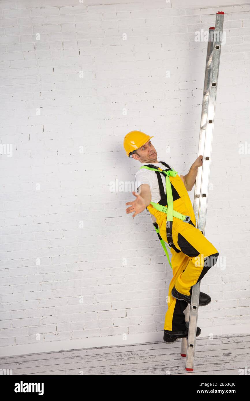 Irresponsible use of a ladder during construction work Stock Photo - Alamy
