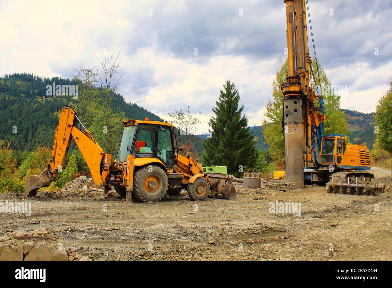 Machinery drilling and backhoe on construction site Stock Photo - Alamy