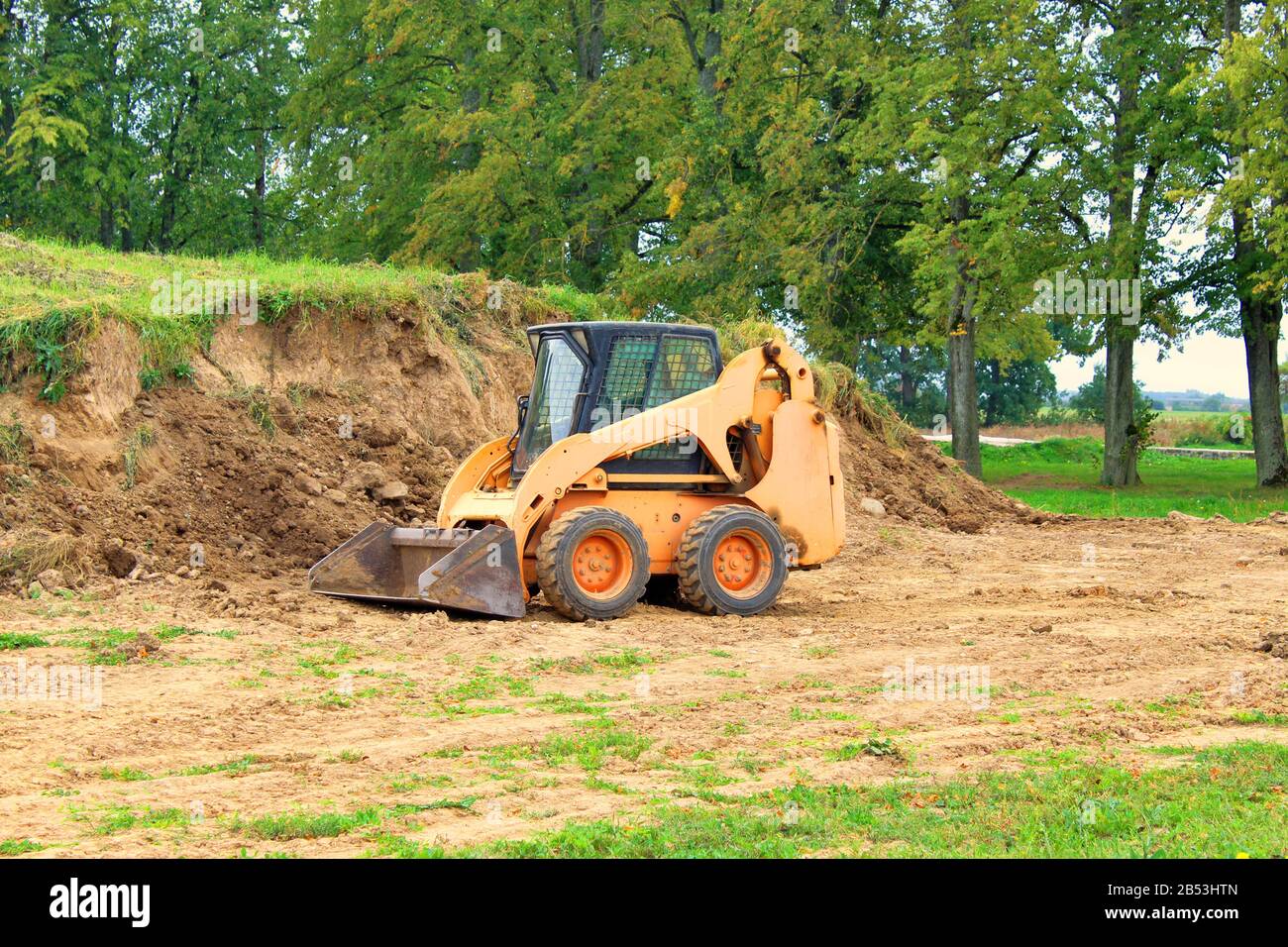 Little excavator on construction site Stock Photo - Alamy