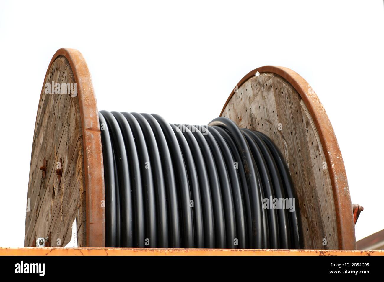 A bobbin or wooden spool with fiber optic cables on a construction site ...