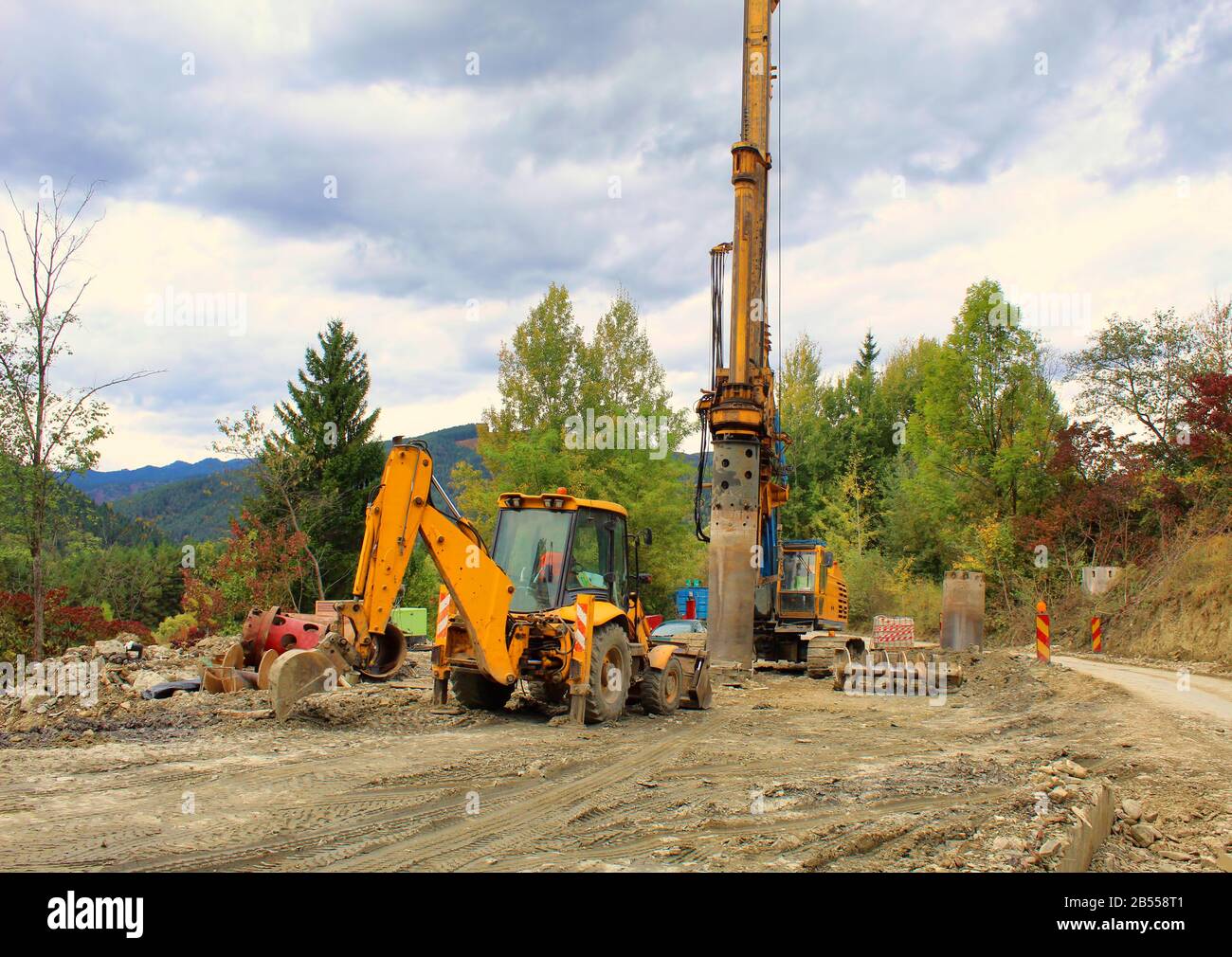 Machinery drilling and backhoe on construction site Stock Photo - Alamy