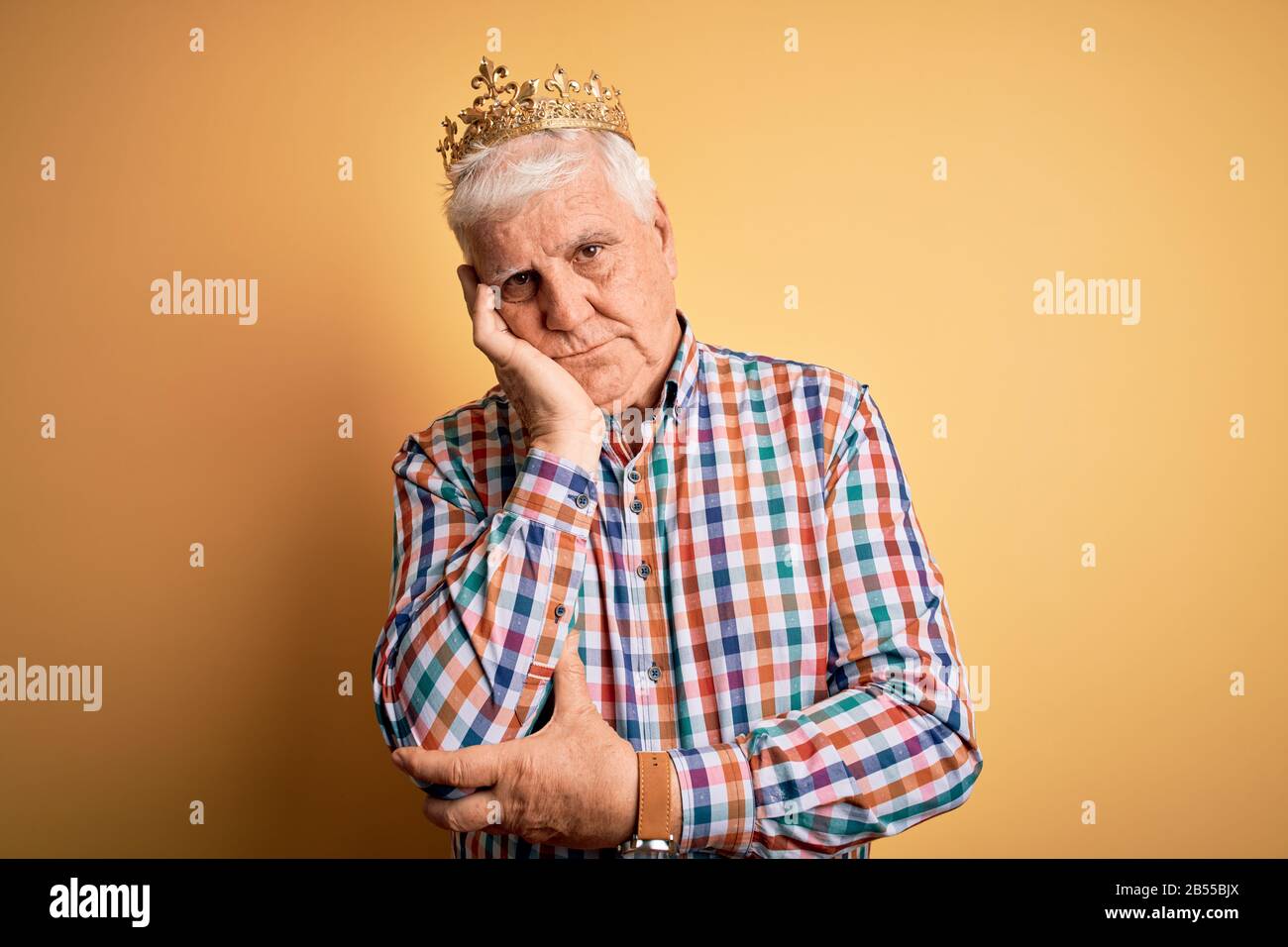 Senior handsome hoary man wearing golden crown of king over isolated ...