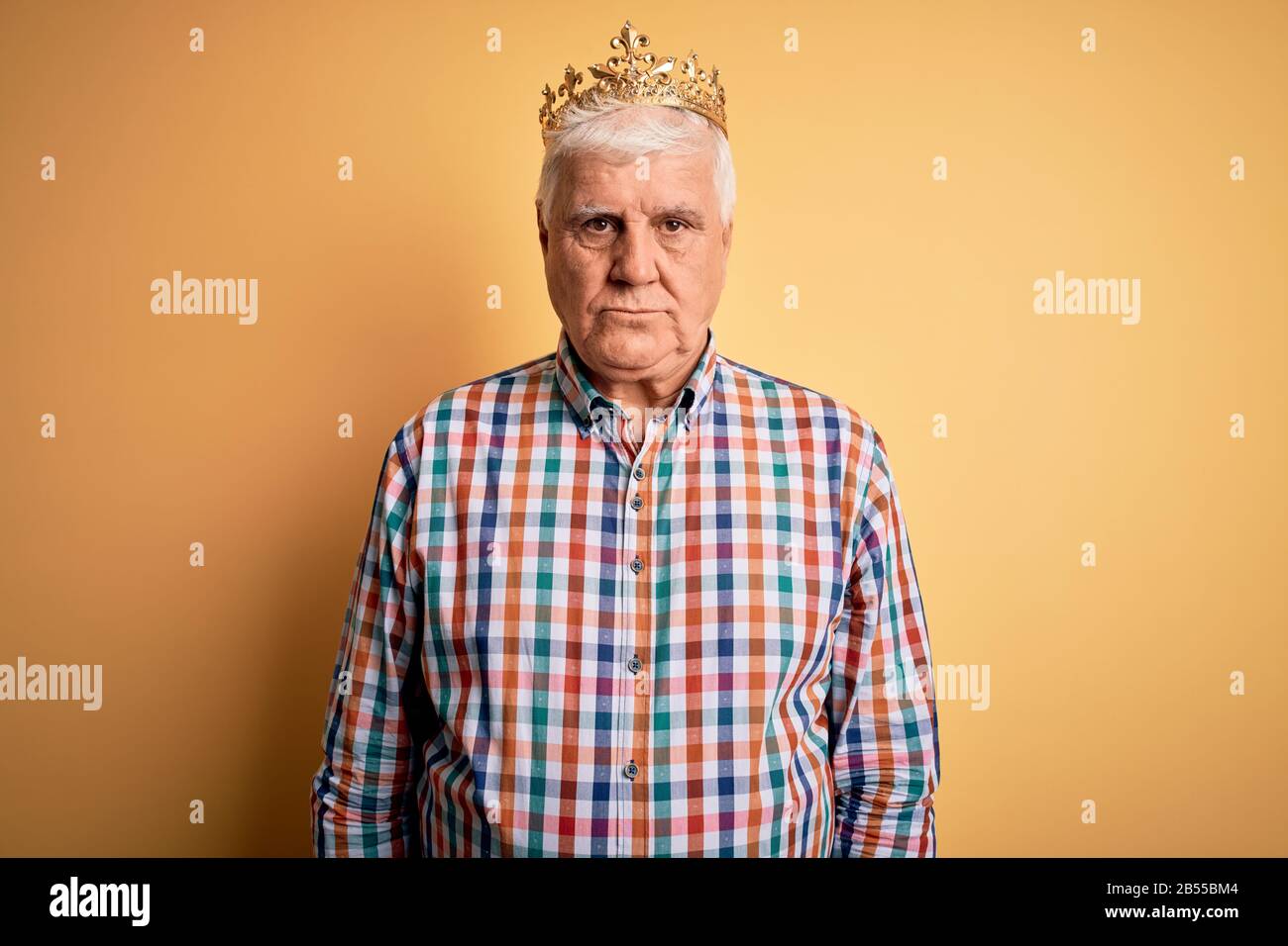 Senior handsome hoary man wearing golden crown of king over isolated ...
