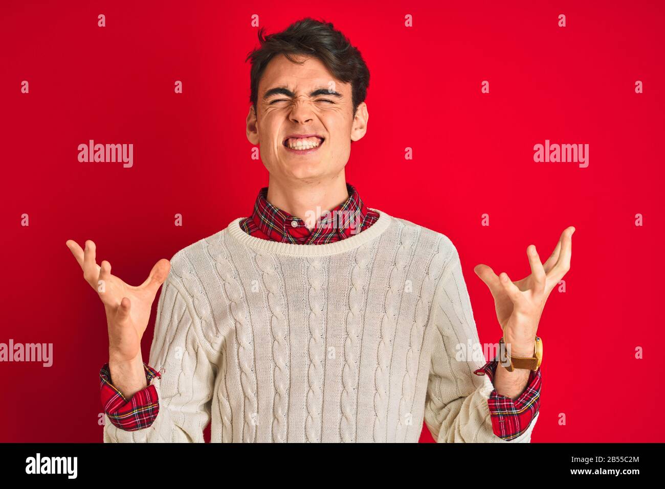 Teenager boy wearing a sweater standing over pink isolated background ...