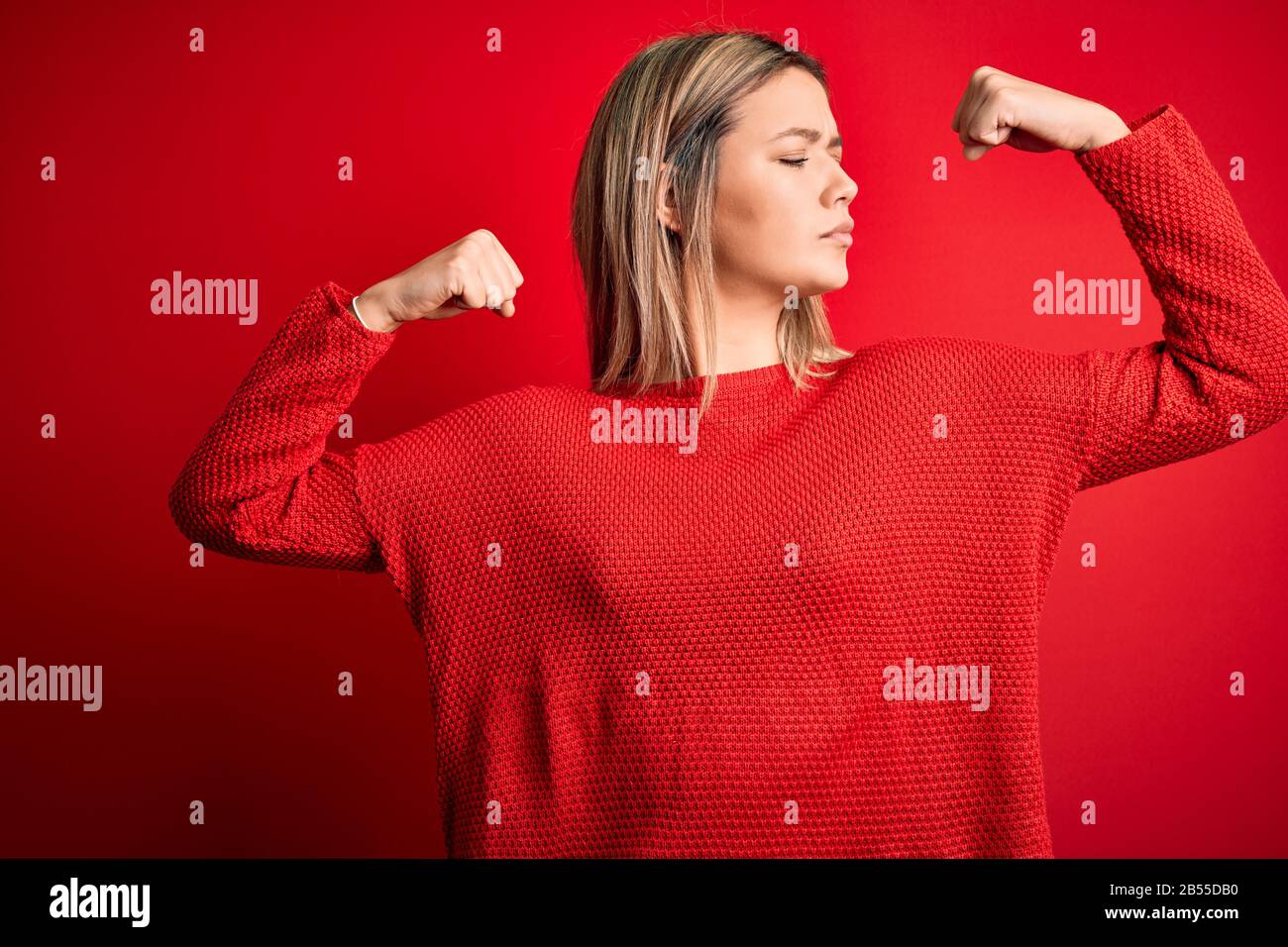 Young beautiful blonde woman wearing casual sweater over red isolated ...