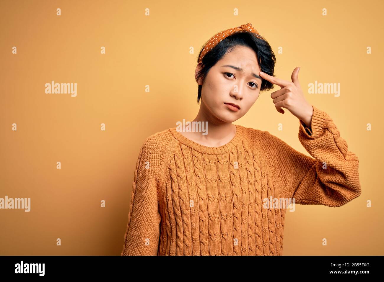 Young beautiful asian girl wearing casual sweater and diadem standing ...