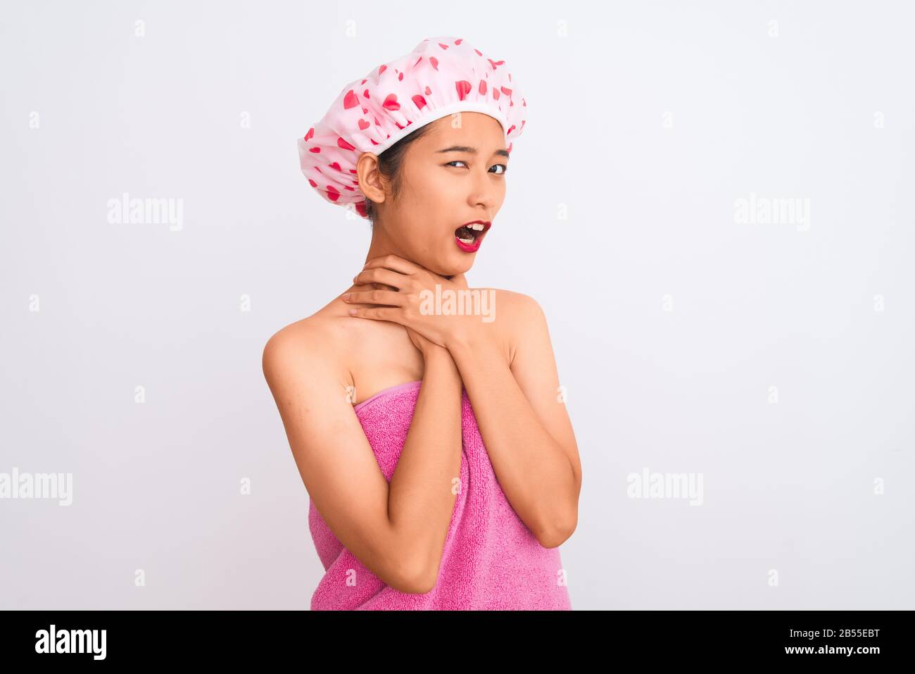 Young chinese woman wearing shower towel and cap bath over isolated ...