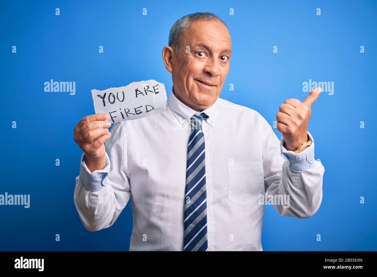 Senior handsome businessman holding you are fired paper over isolated ...