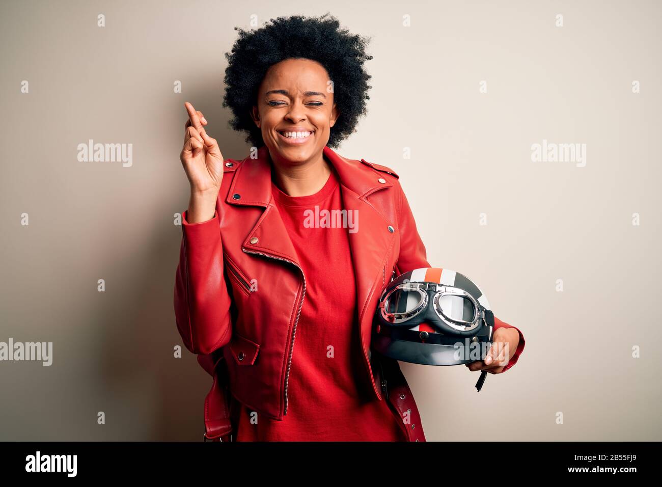 Young African American afro motorcyclist woman with curly hair holding ...