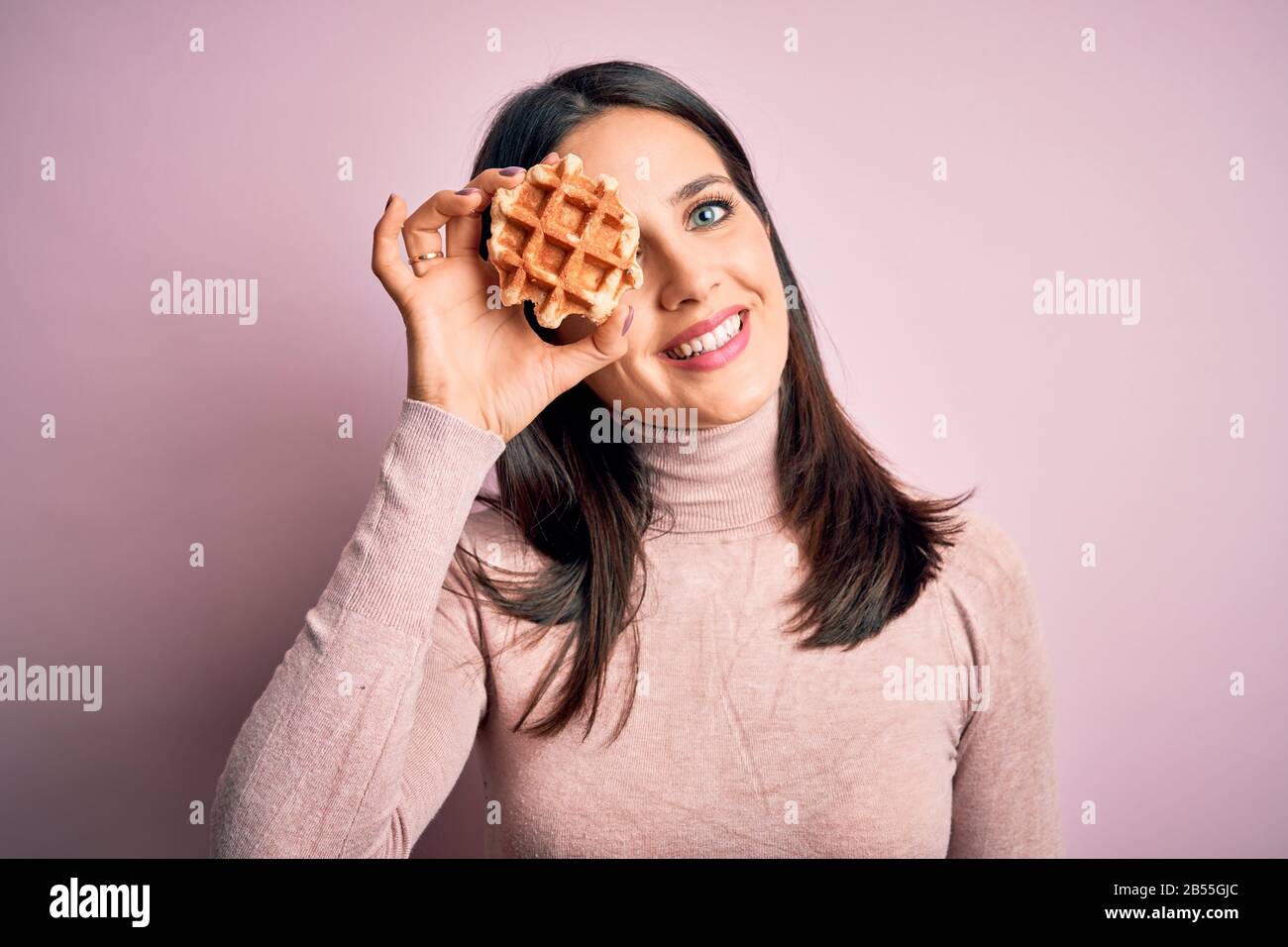Young brunette woman with blue eyes eating sweet waffle for breakfast ...