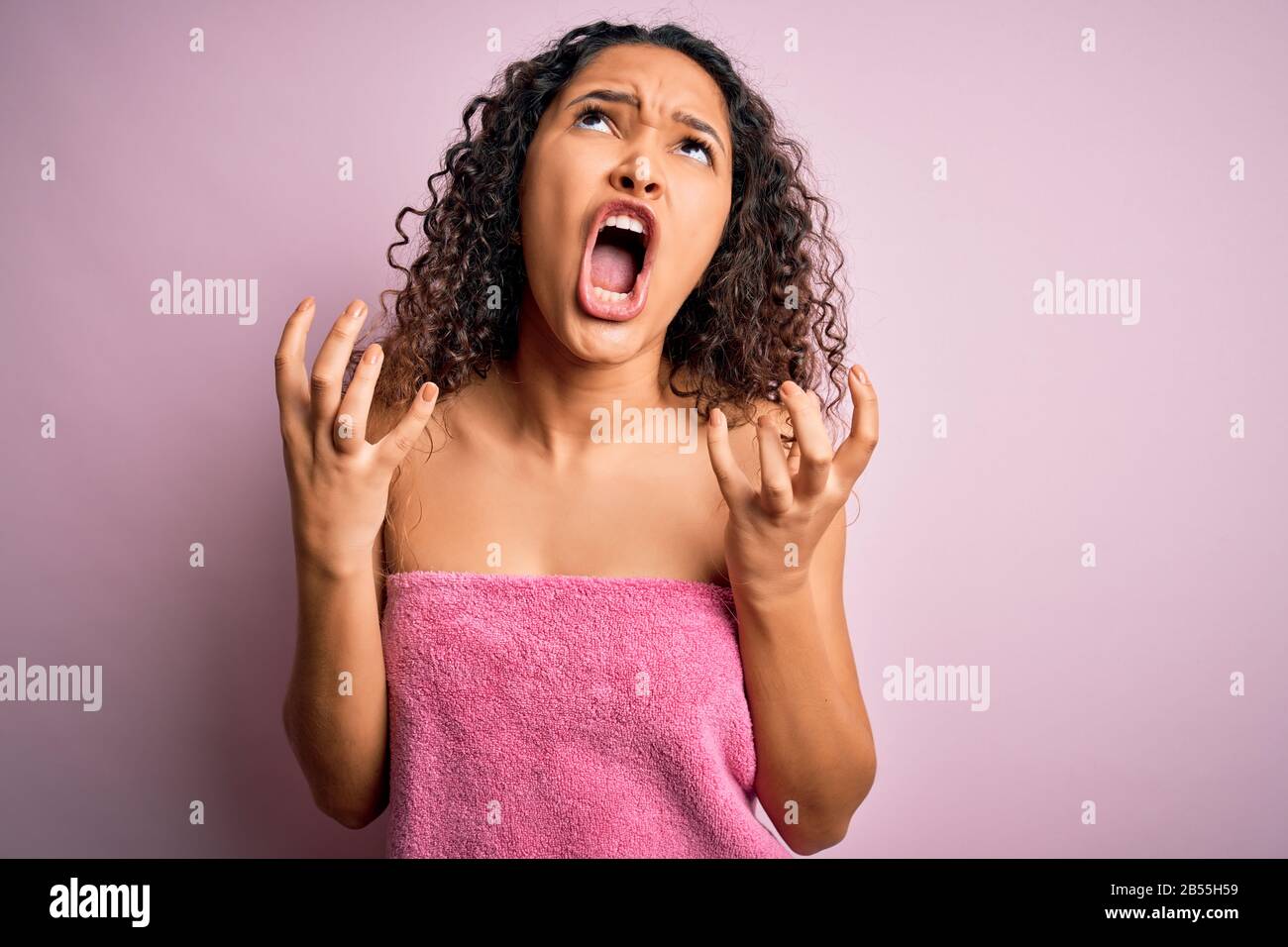 Young beautiful woman with curly hair wearing shower towel after bath ...