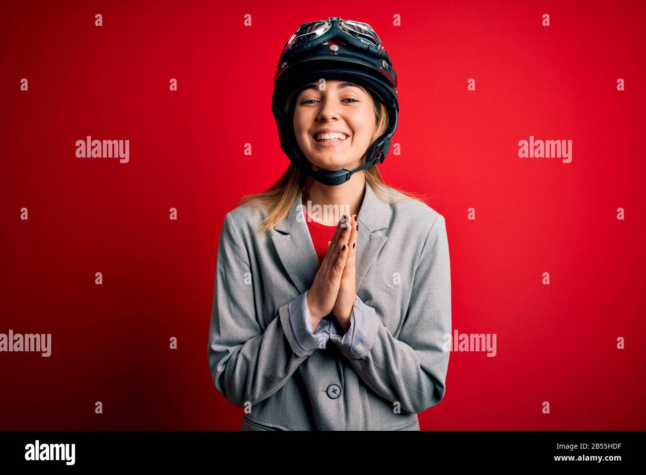 Young beautiful blonde motorcyclist woman wearing motorcycle helmet ...