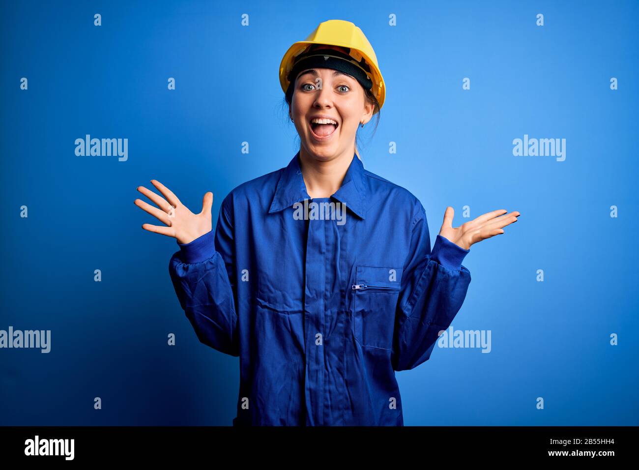 Young Beautiful Worker Woman With Blue Eyes Wearing Security Helmet And