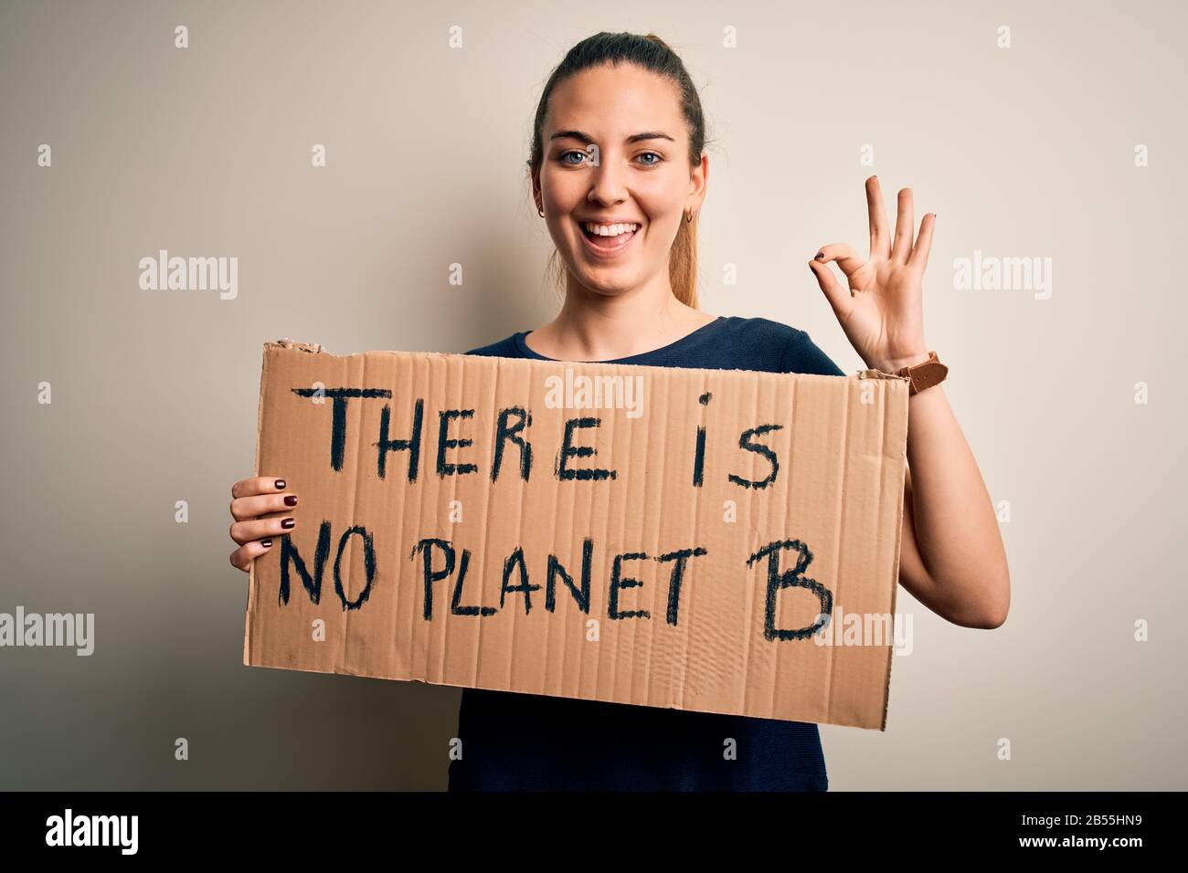 Young beautiful blonde woman with blue eyes asking for protect planet ...