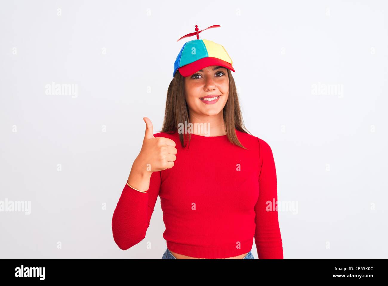 Young beautiful girl wearing fanny cap with propeller standing over ...