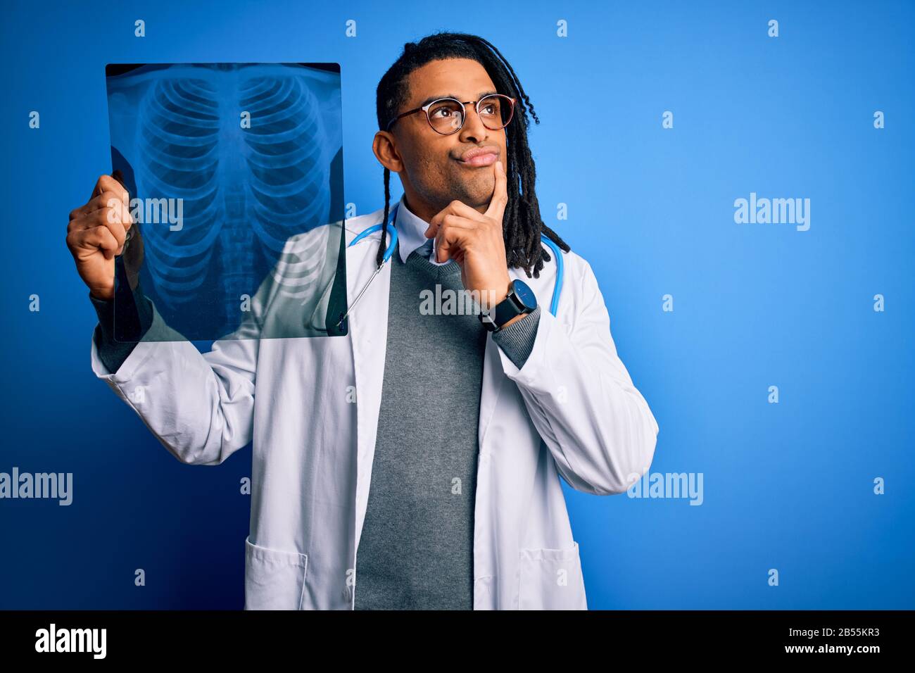 Young african american afro doctor man with dreadlocks holding chest ...
