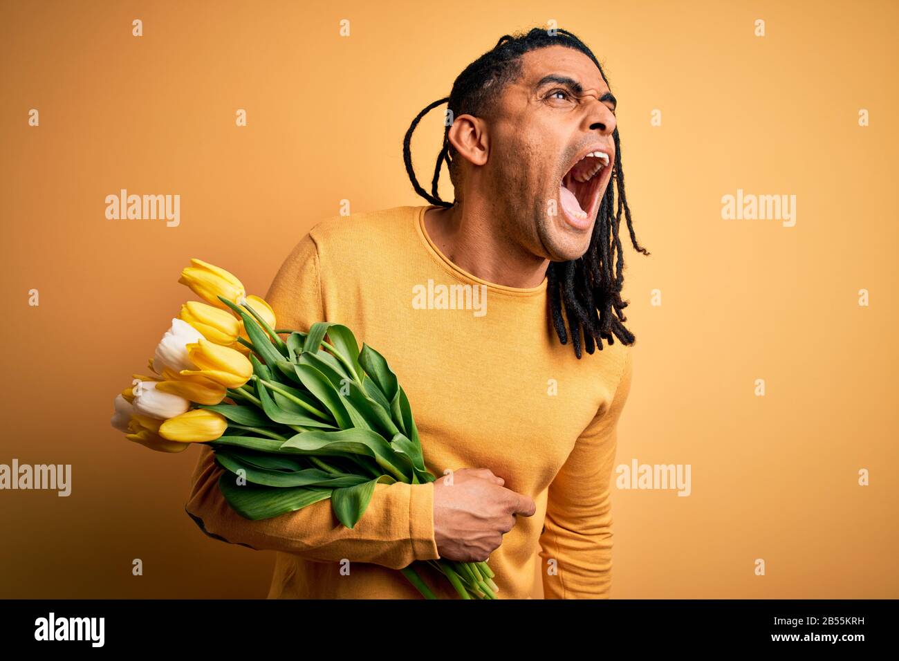 Young african american afro romantic man with dreadlocks holding ...