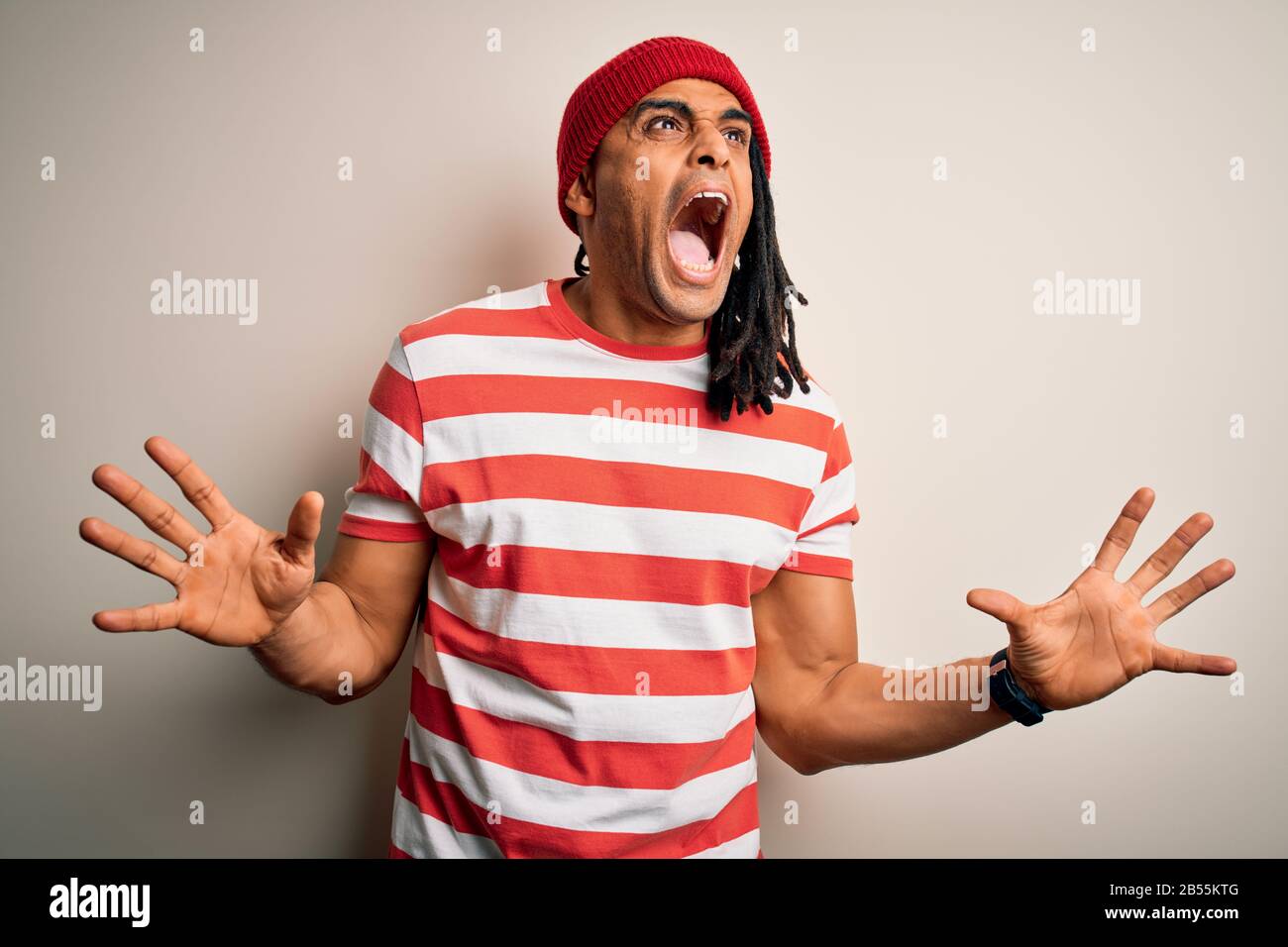 Young handsome african american man with dreadlocks wearing striped t ...