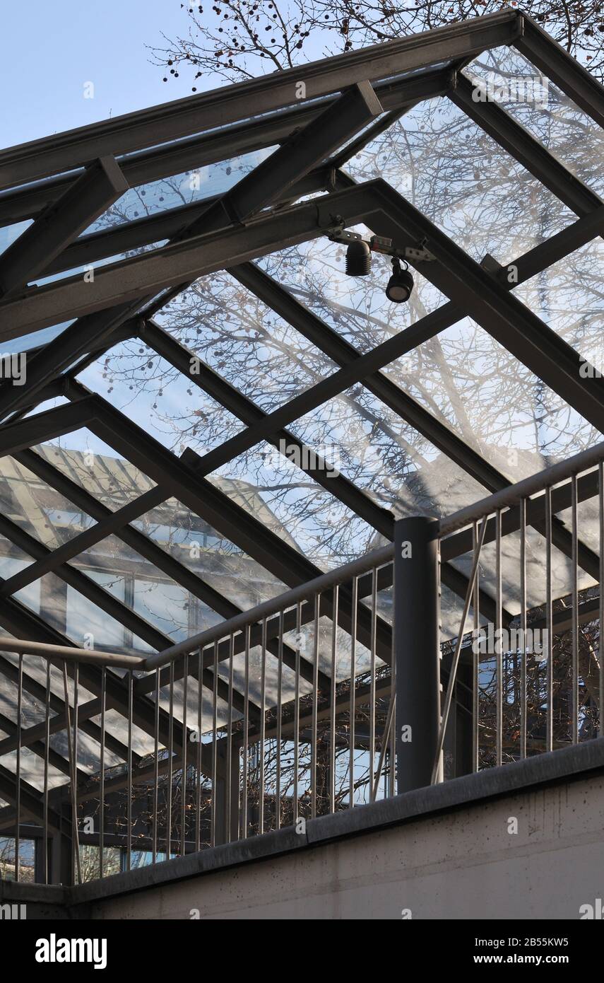 view to pedestrian footbridge with roof of glass and steel in business ...