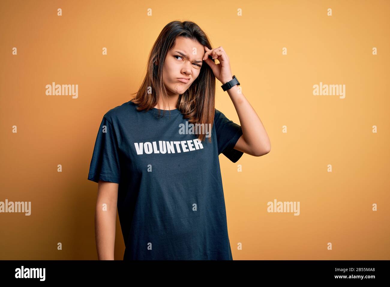 Young beautiful brunette girl doing volunteering wearing t-shirt with ...