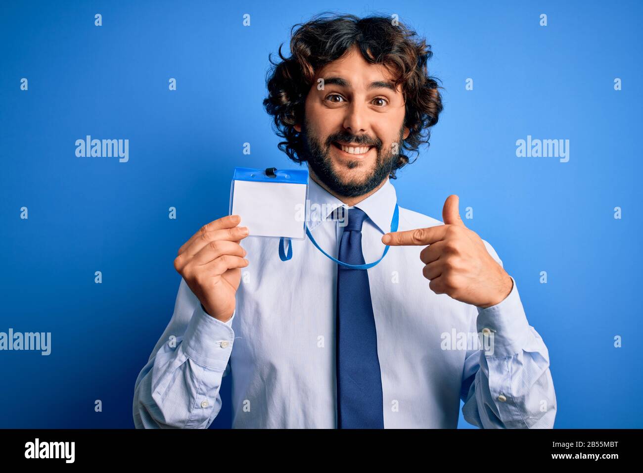 Young handsome business man with beard holding id card identification ...