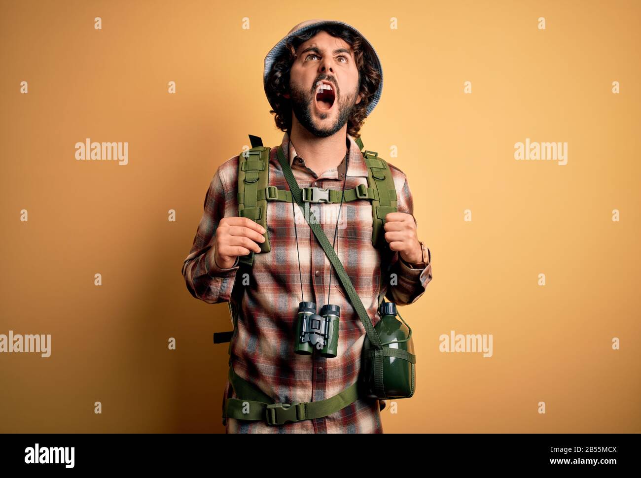 Young hiker man with curly hair and beard hiking wearing backpack and ...
