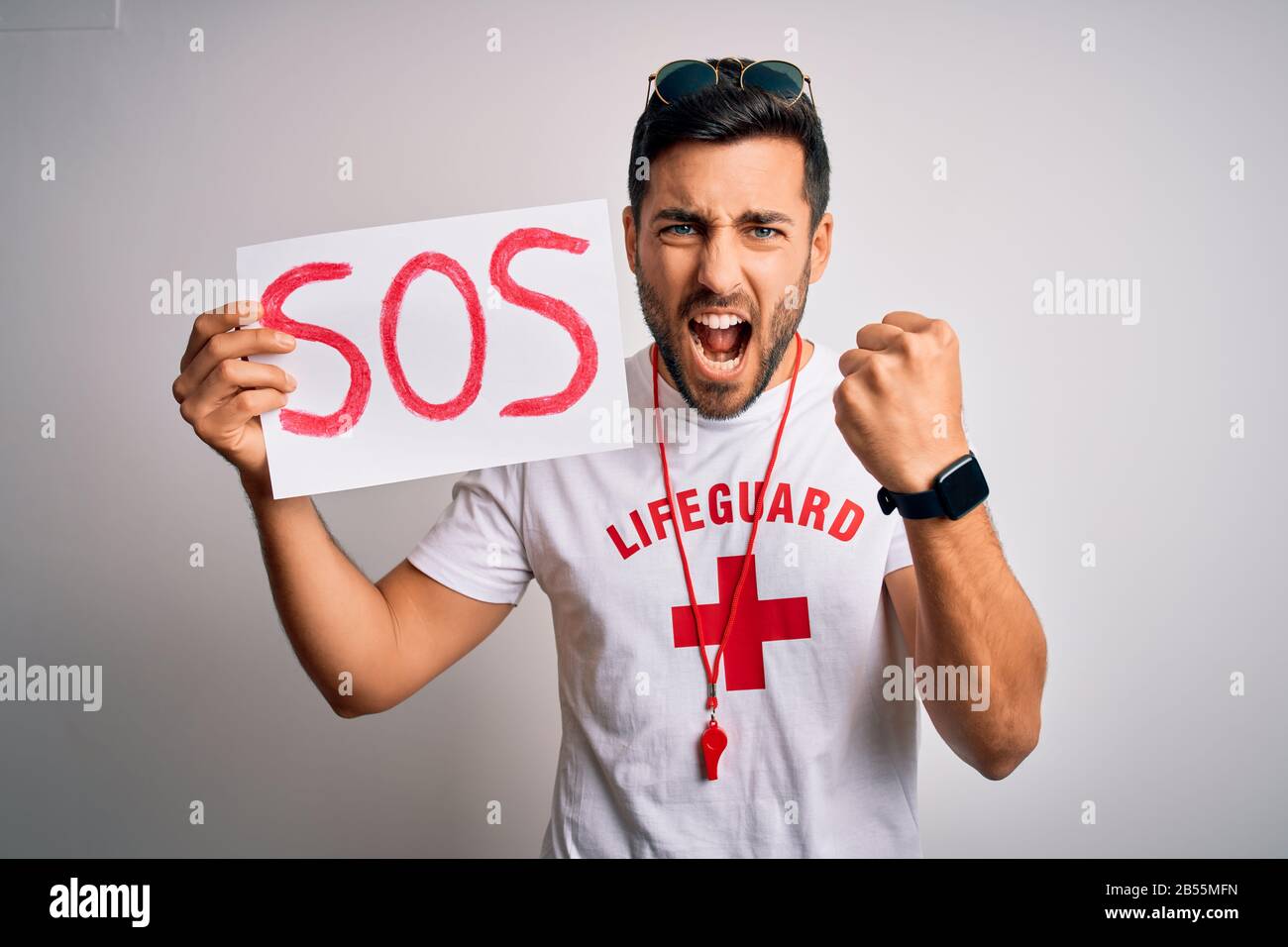 Young lifeguard man with beard wearing whistle holding paper with sos ...
