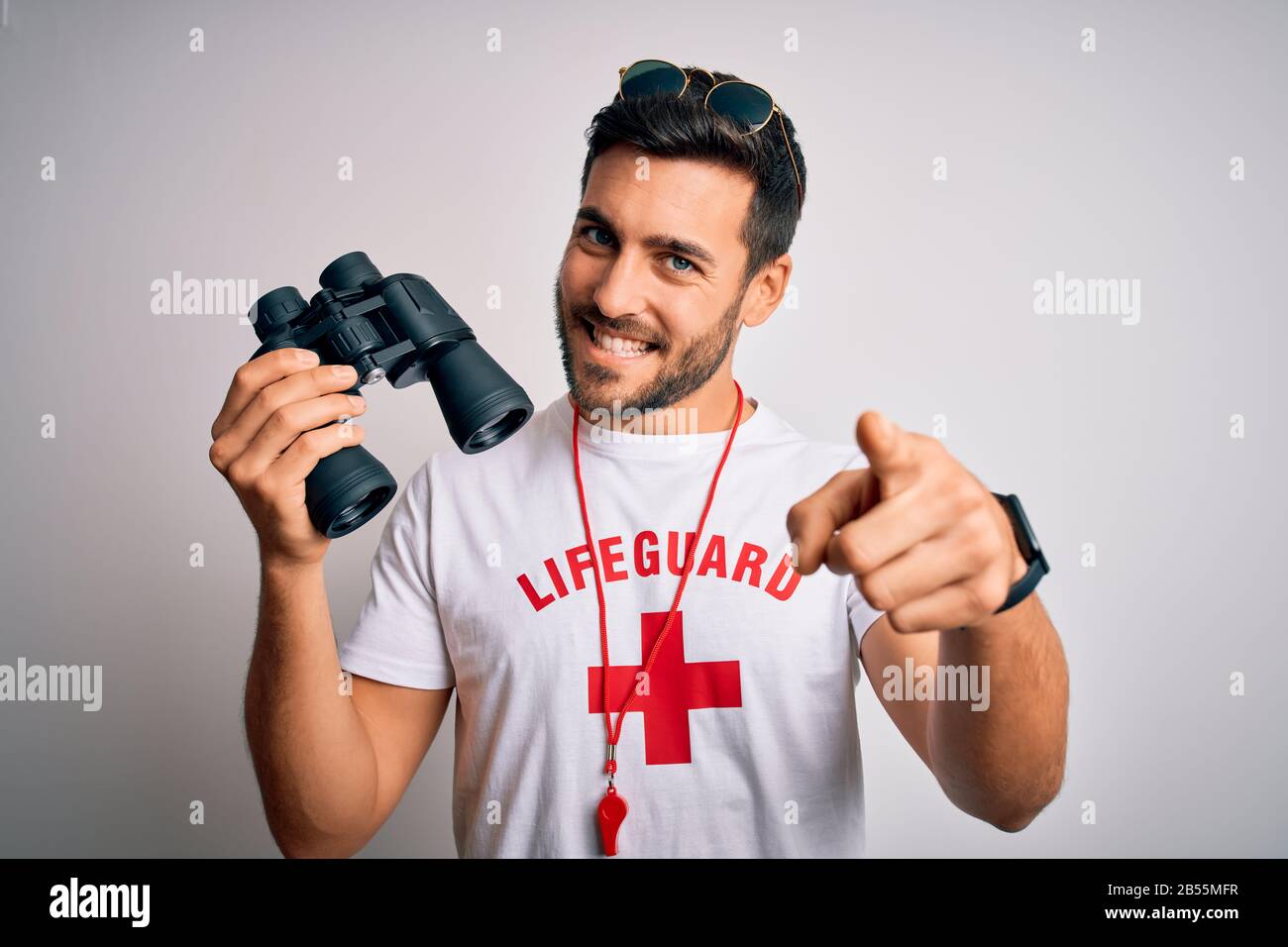 Young lifeguard man with beard wearing t-shirt with red cross and ...