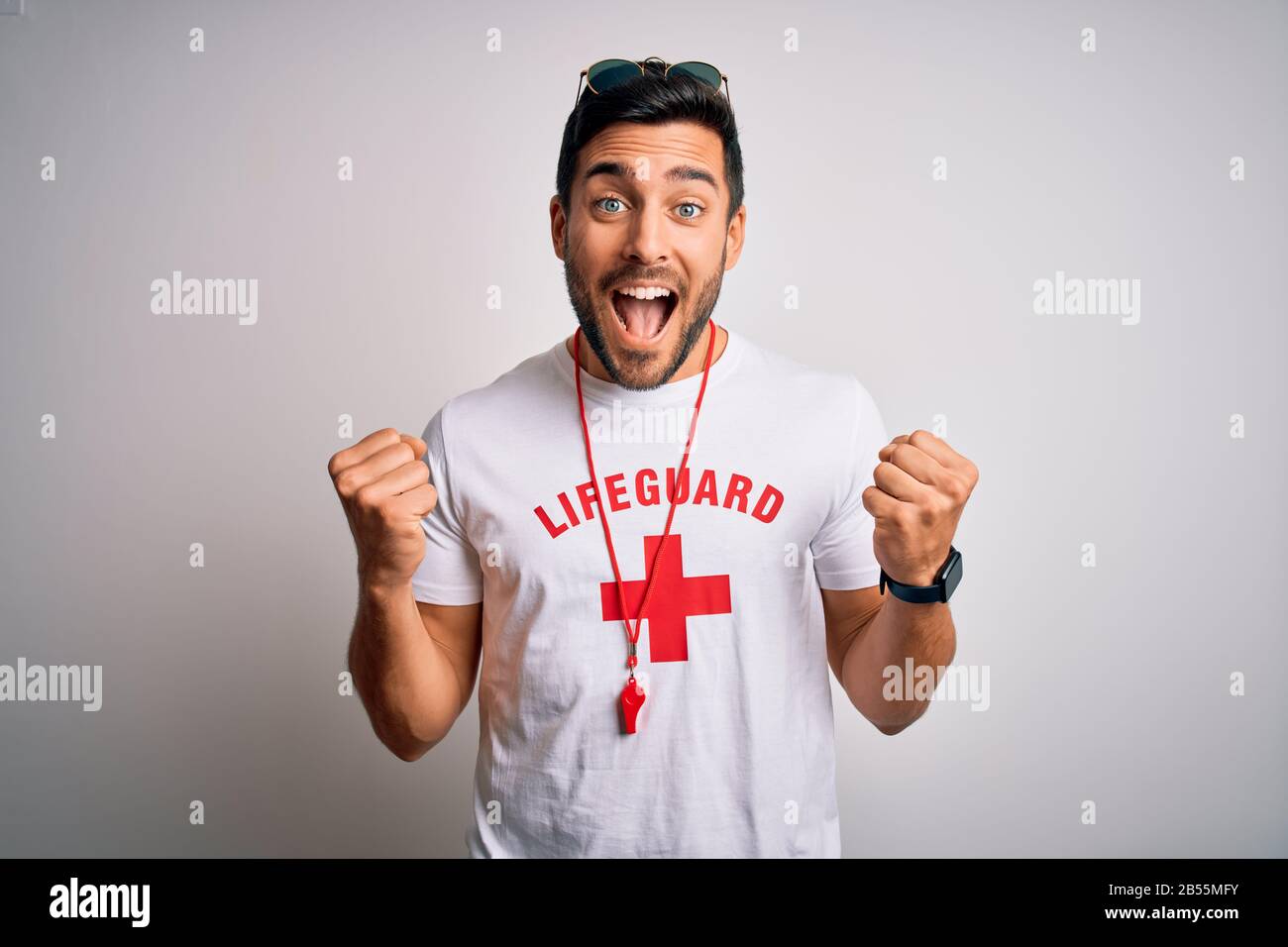 Young handsome lifeguard man with beard wearing t-shirt with red cross ...