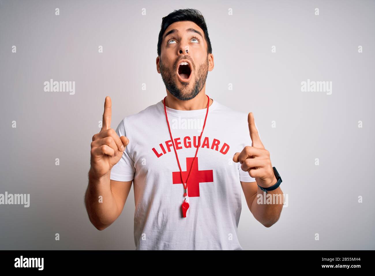 Young handsome lifeguard man with beard wearing t-shirt with red cross ...