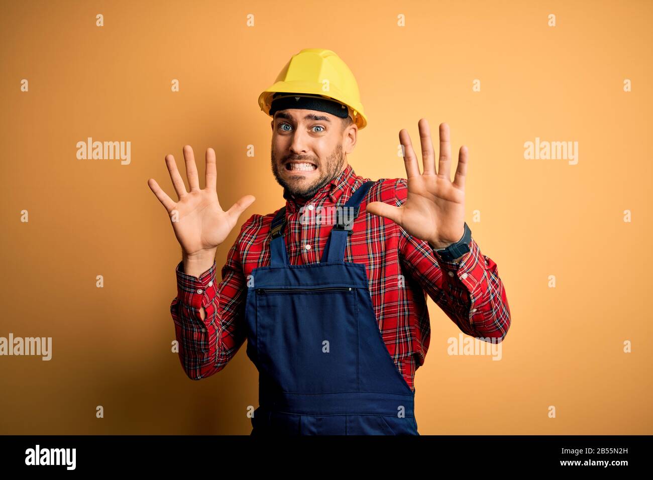 Young builder man wearing construction uniform and safety helmet over ...