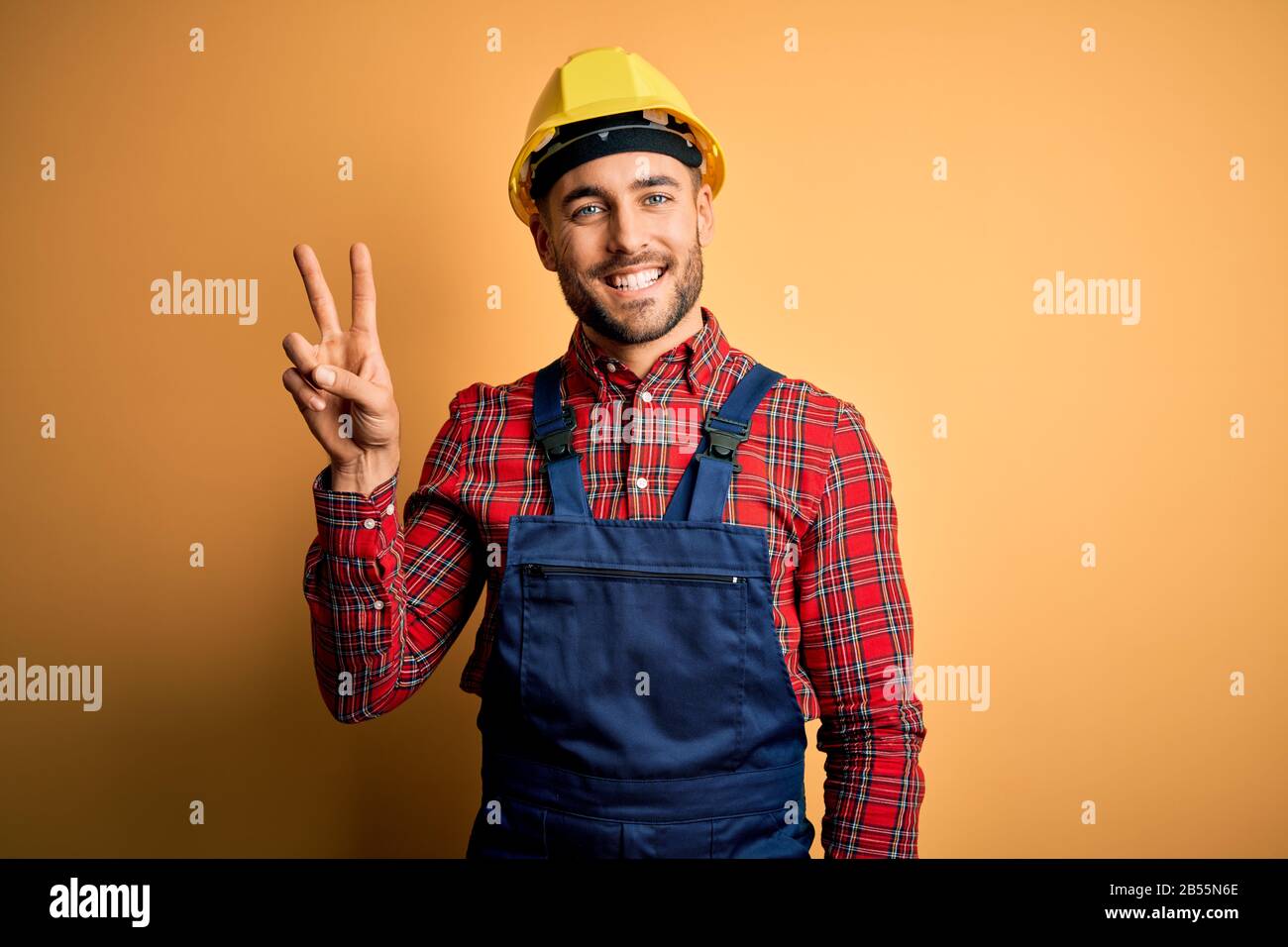 Young builder man wearing construction uniform and safety helmet over ...