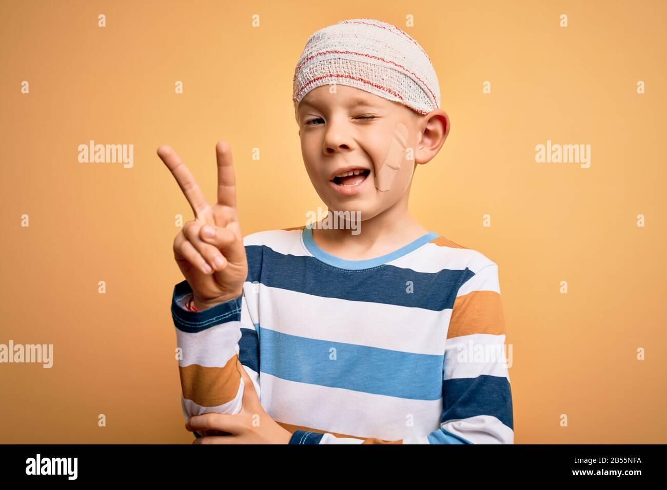 Young little caucasian kid injured wearing medical bandage on head over ...