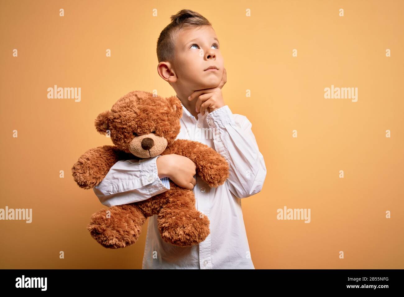 Young little caucasian kid hugging teddy bear stuffed animal over ...