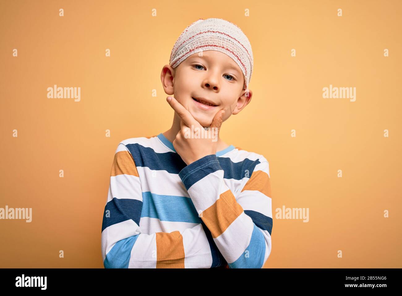 Young little caucasian kid injured wearing medical bandage on head over ...