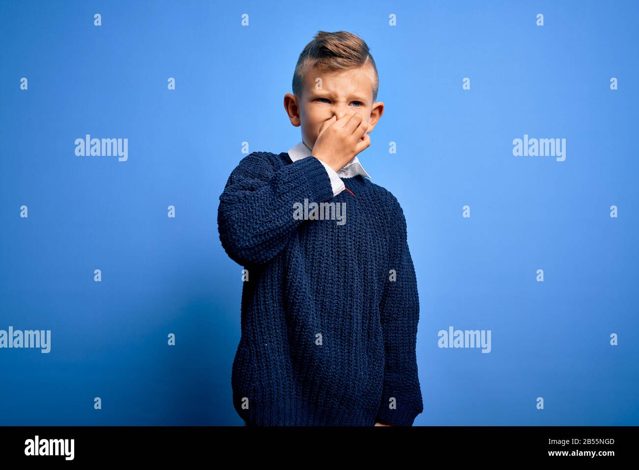 Young little caucasian kid with blue eyes wearing winter sweater over ... Young little caucasian kid with blue eyes wearing winter sweater over ...