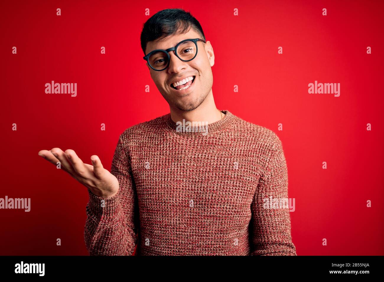 Young handsome hispanic man wearing nerd glasses over red background ...