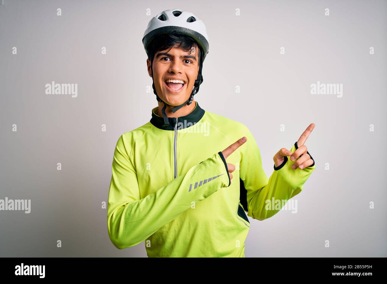 Young handsome cyclist man wearing security bike helmet over isolated ...