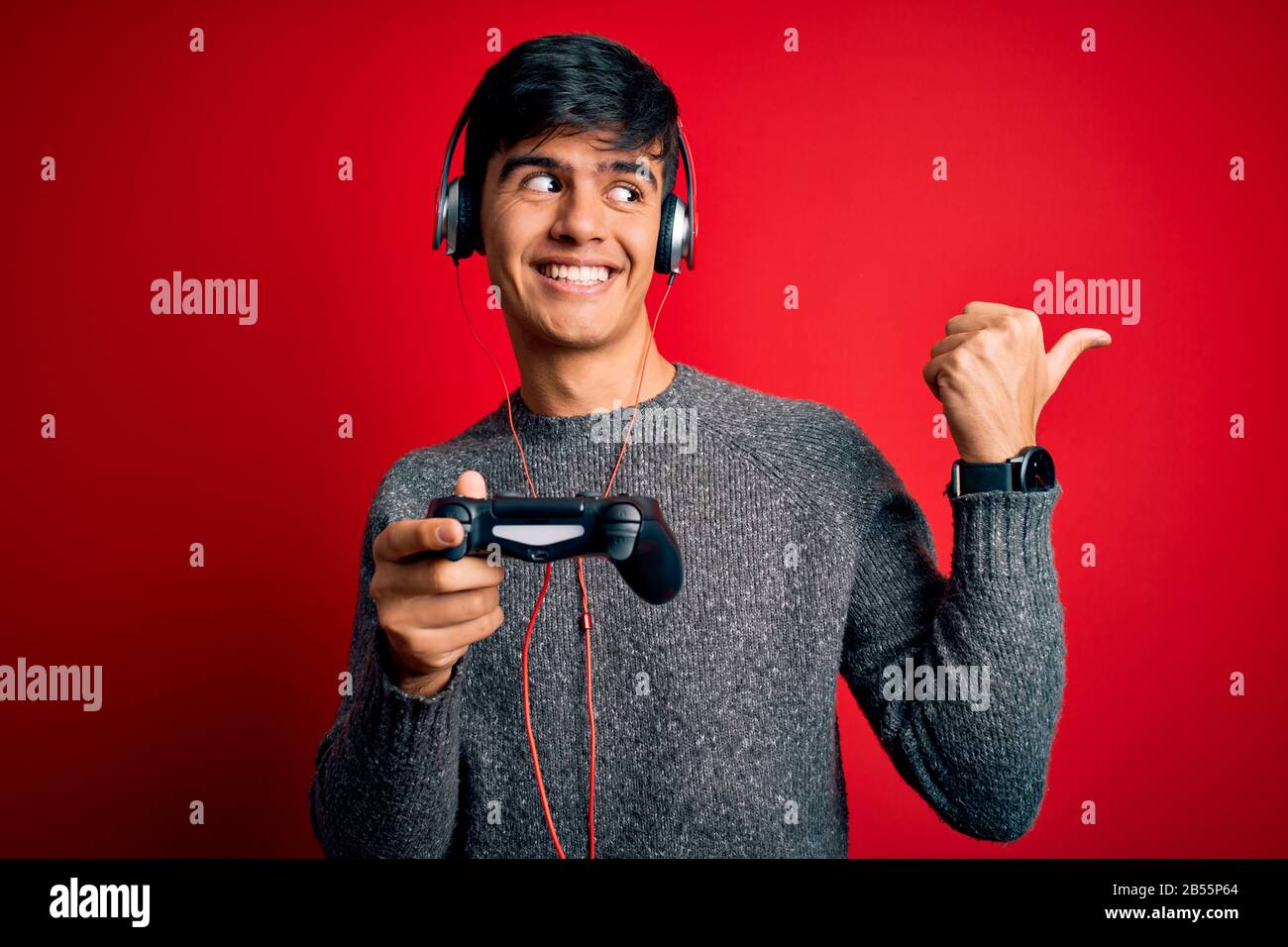 Young handsome gamer man playing video game using joystick and ...
