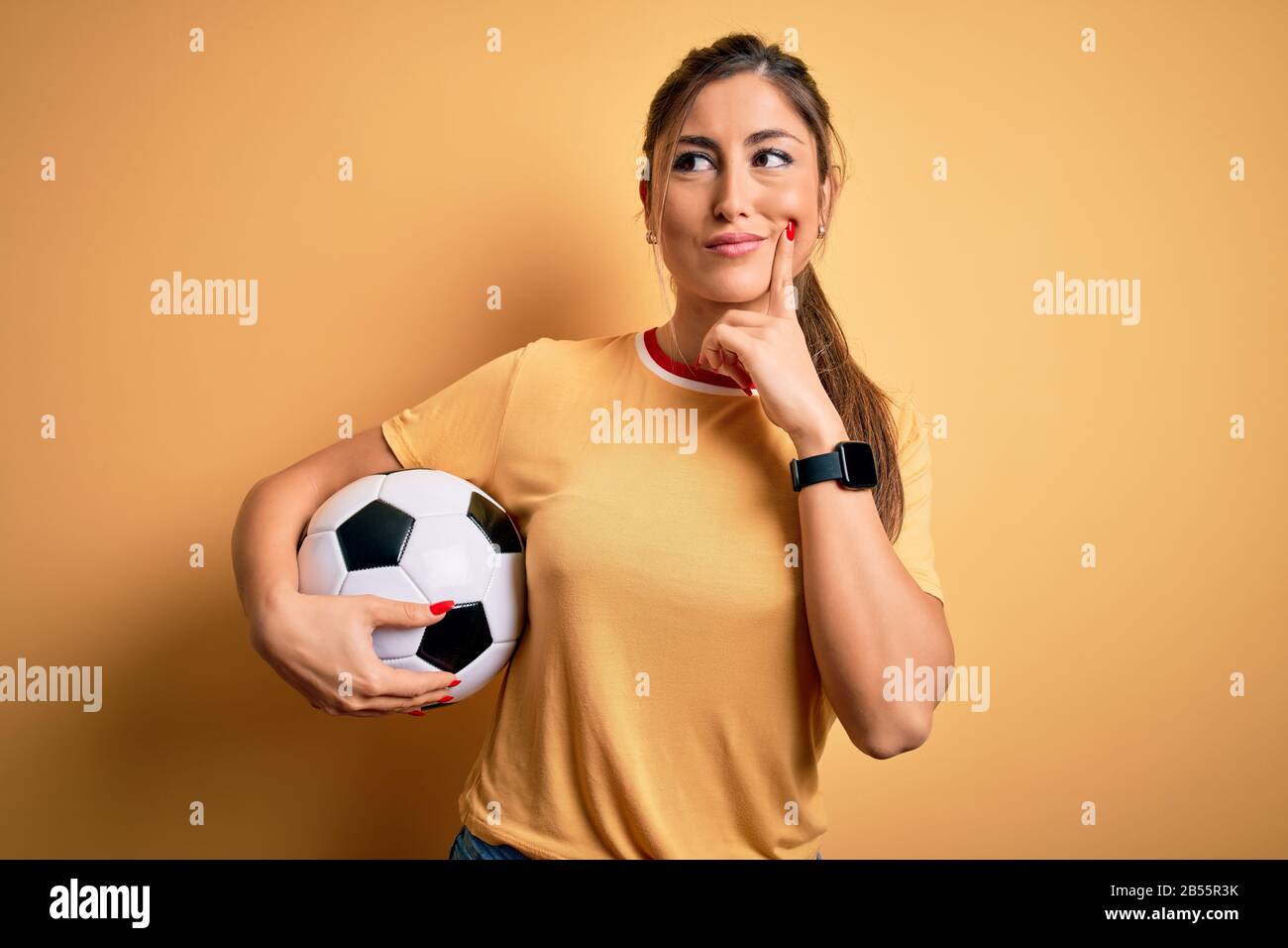 Beautiful brunette player woman playing soccer using football ball over ...