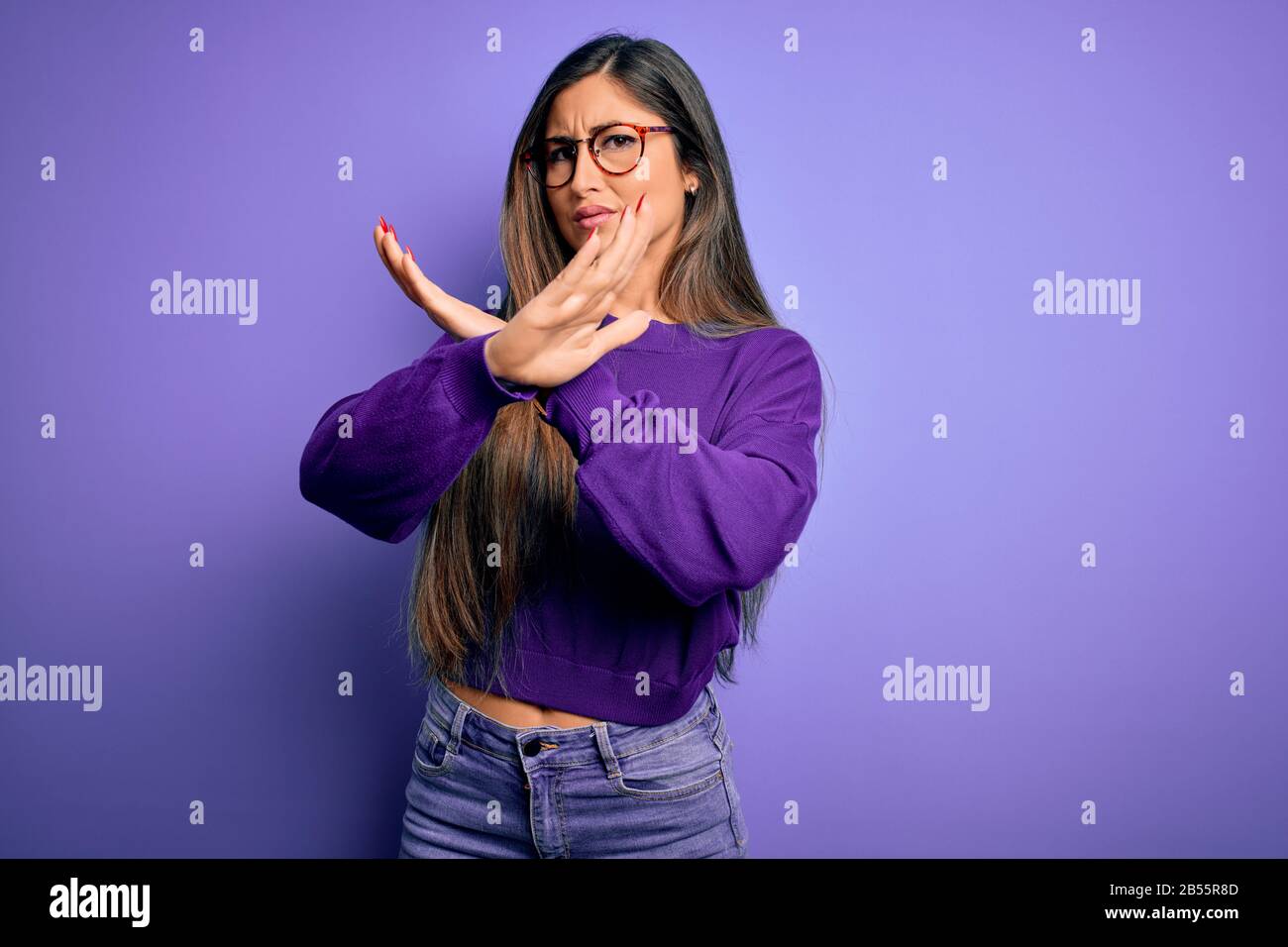 Young beautiful smart woman wearing glasses over purple isolated background Rejection expression ...
